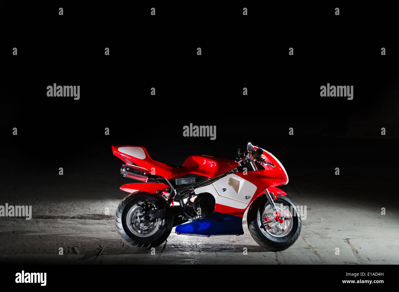 Photograph of a mini moto in a disused warehouse with a black ...