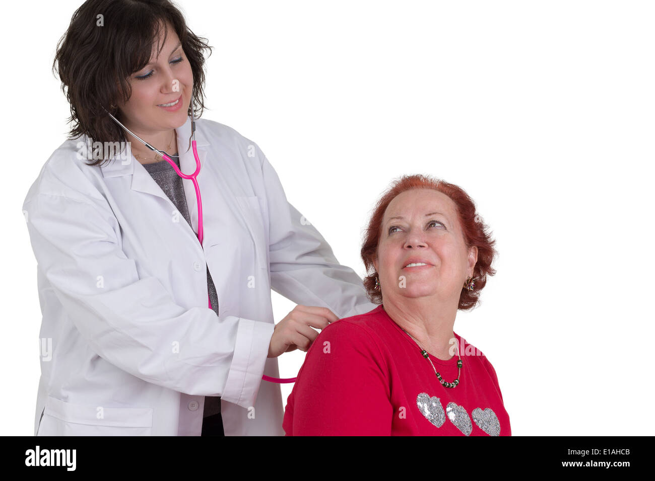 Female doctor examining an elderly woman patient with a stethoscope in ...