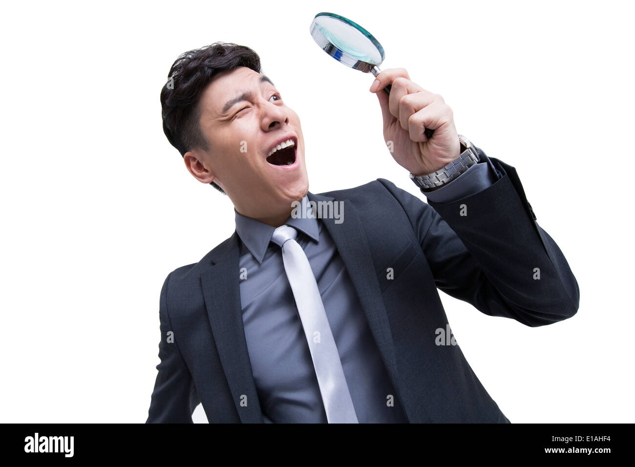Young businessman looking through magnifying glass Stock Photo - Alamy