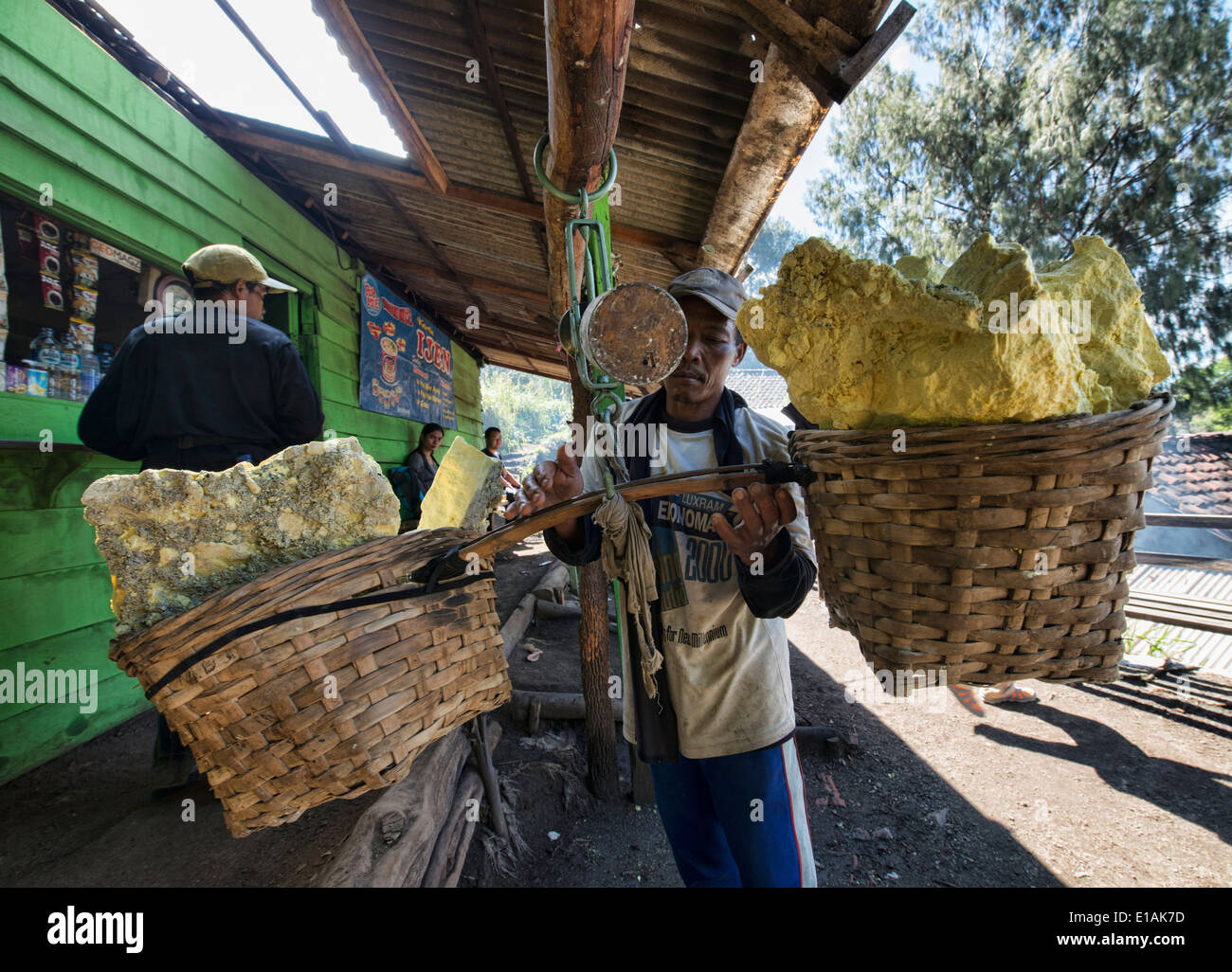 Miner weighing his load of sulphur for payment at the Kawah Ijen ...