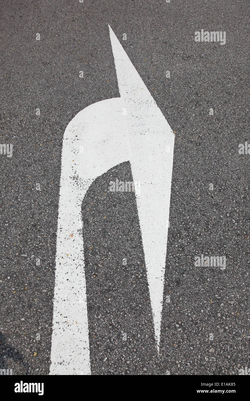 It's a photo of a white arrow that is painted on the road on the floor ...