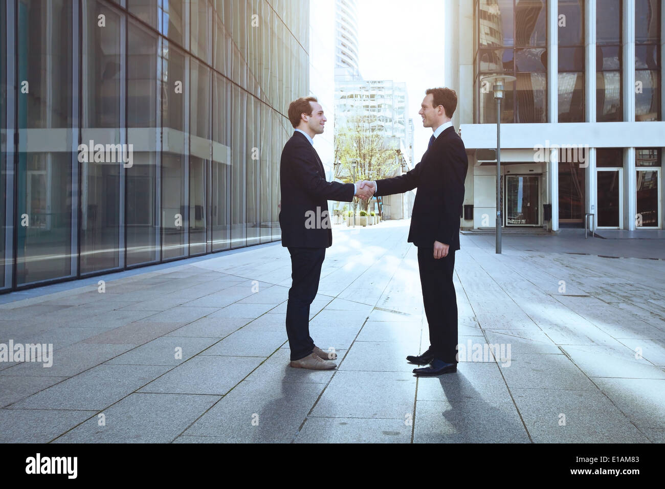 Two business men shaking hands in office hallway Stock Photo - Alamy