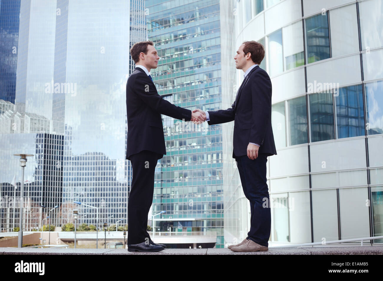 partnership, two businessman on office buildings background Stock Photo ...