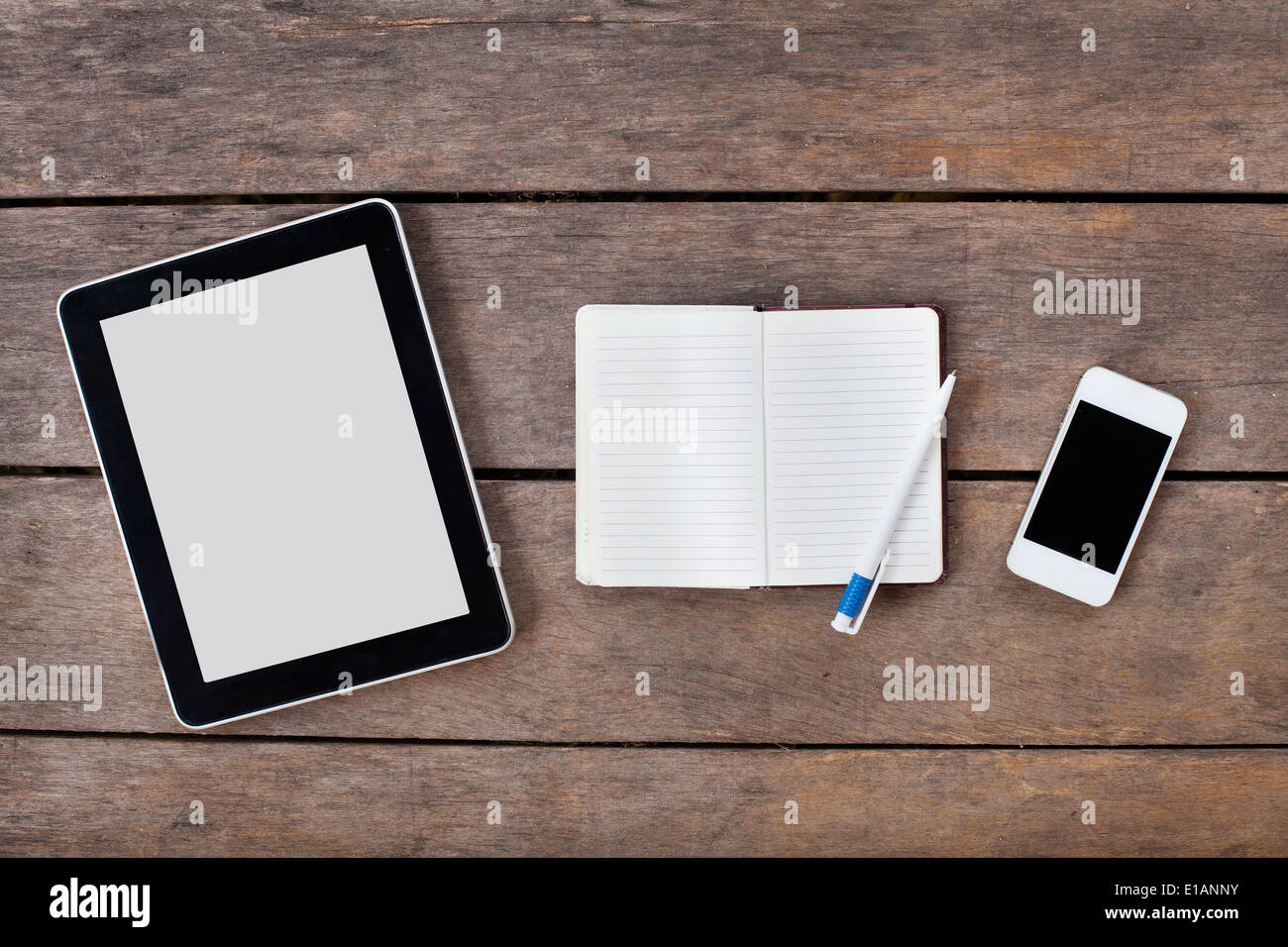 tablet and smartphone on wooden desk Stock Photo - Alamy