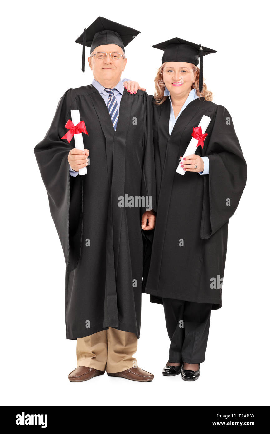 Full length portrait of a mature couple in graduation gowns with ...