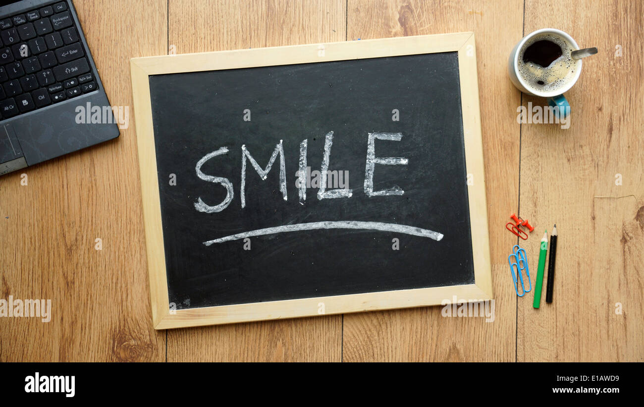Smile written on a chalkboard at the office Stock Photo - Alamy