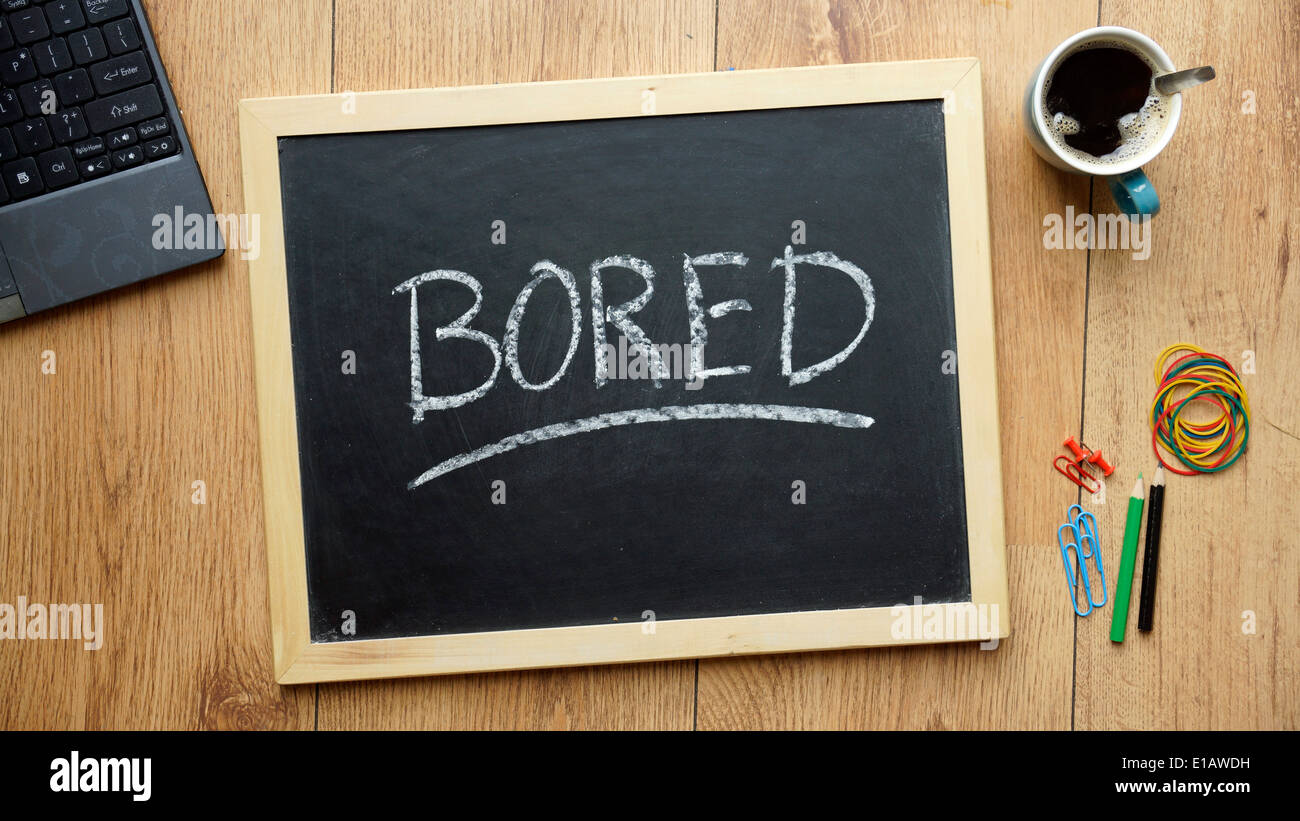Bored written on a chalkboard at the office Stock Photo - Alamy