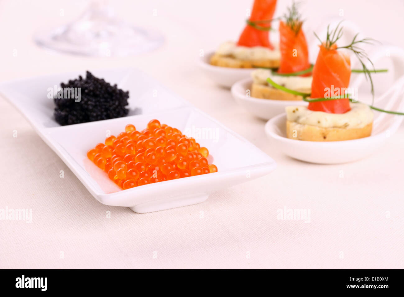 Red caviar, smoked salmon rolls on white bread chunks, top view Stock ...