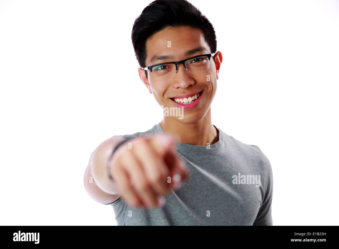Smiling young man pointing finger at you against white background Stock ...