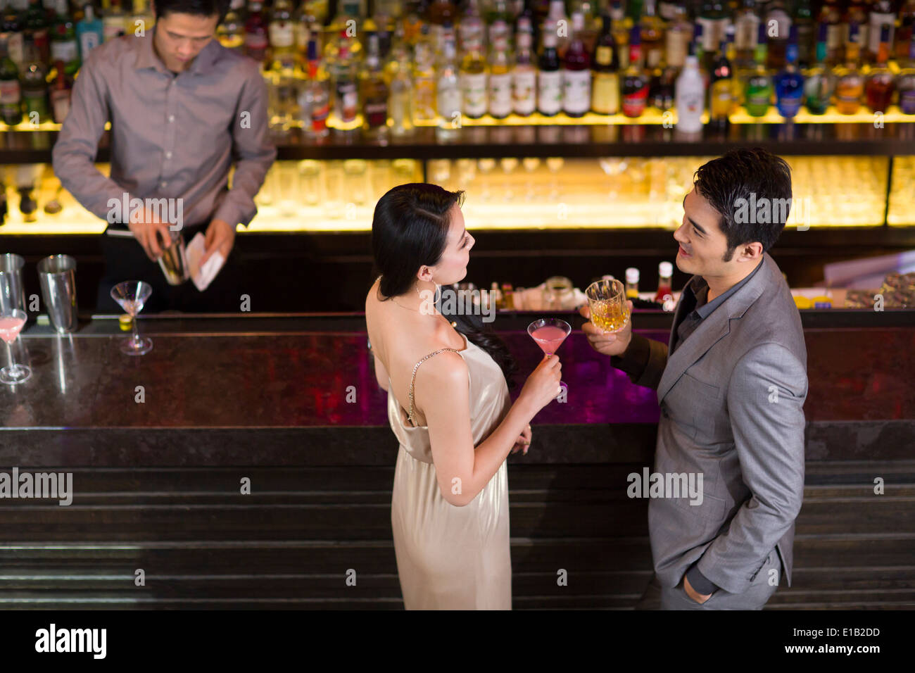 Young man and woman chatting at bar Stock Photo - Alamy