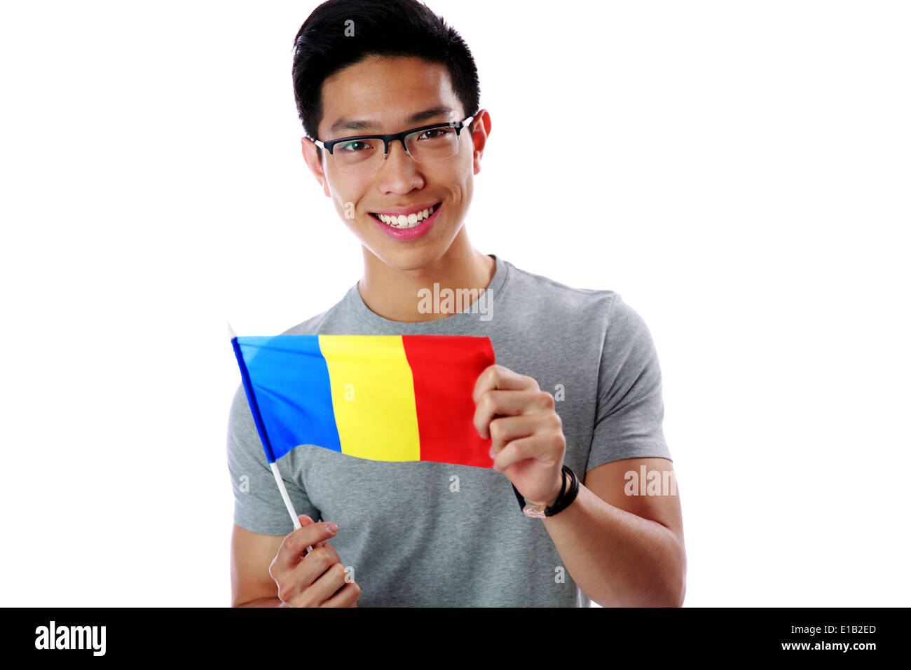 Happy young asian man holding flag of Romania isolated on white ...