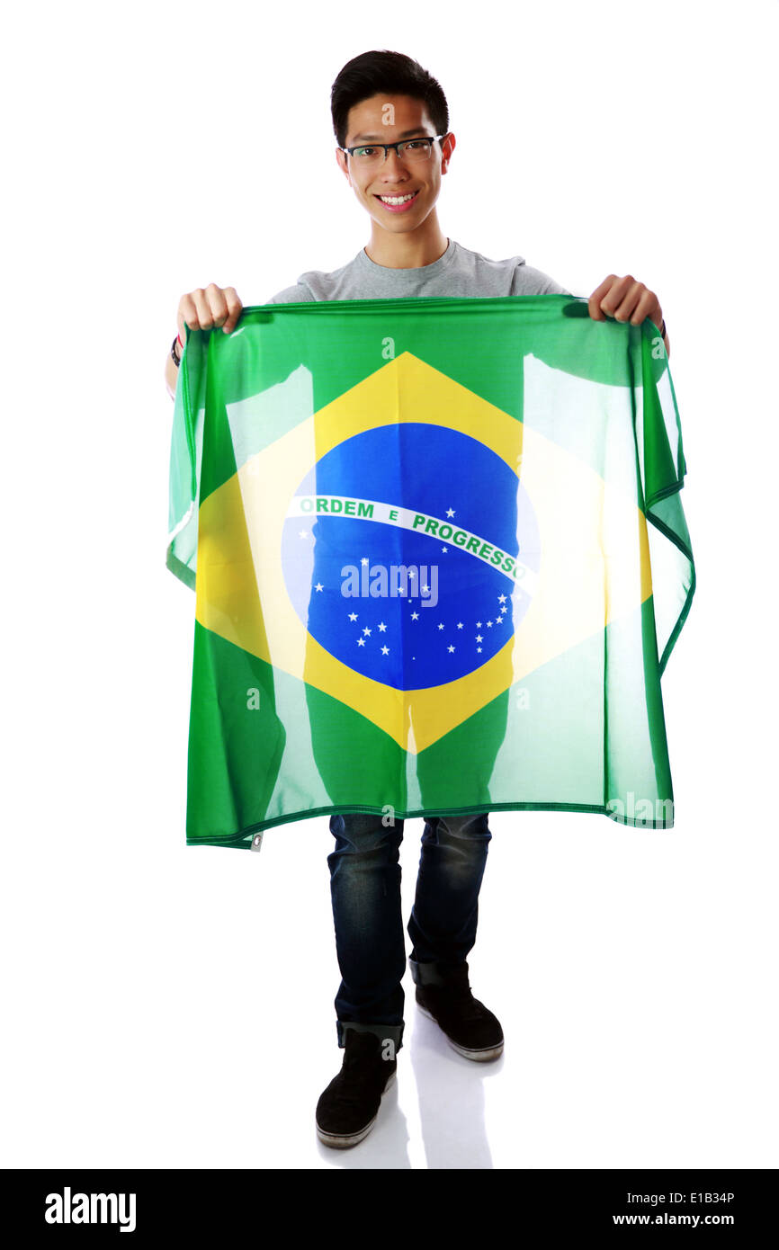 Portrait of a young asian man holding Brazilian flag over white ...