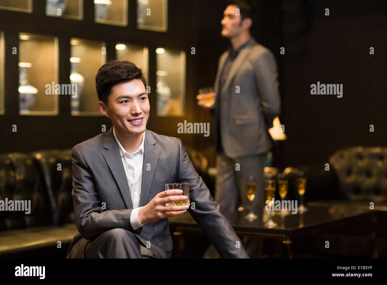Business partners drinking alcohol in luxury club Stock Photo - Alamy