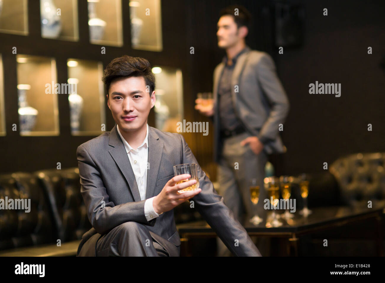 Business partners drinking alcohol in luxury club Stock Photo - Alamy
