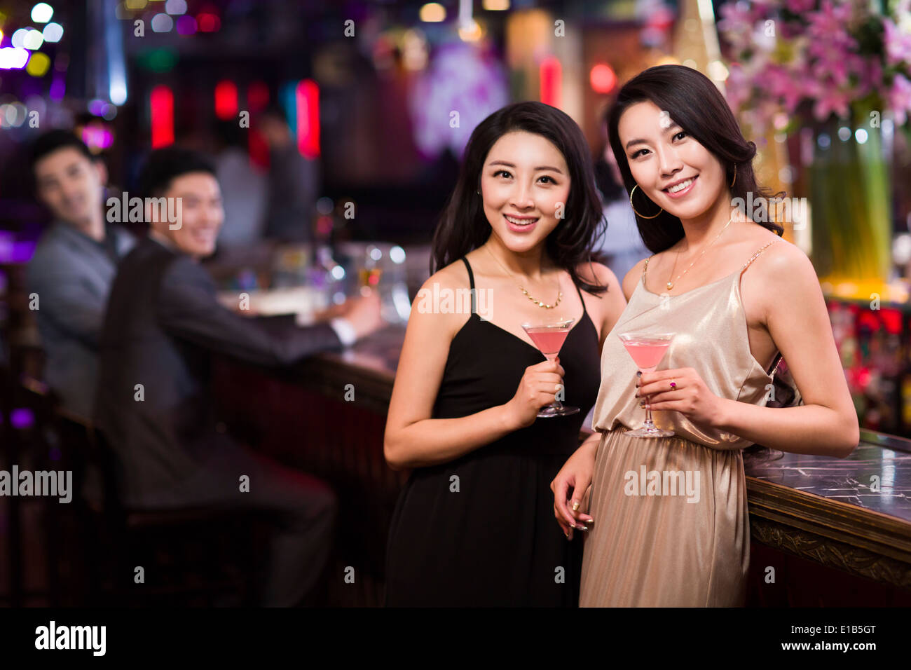 Young women drinking cocktail in bar Stock Photo - Alamy