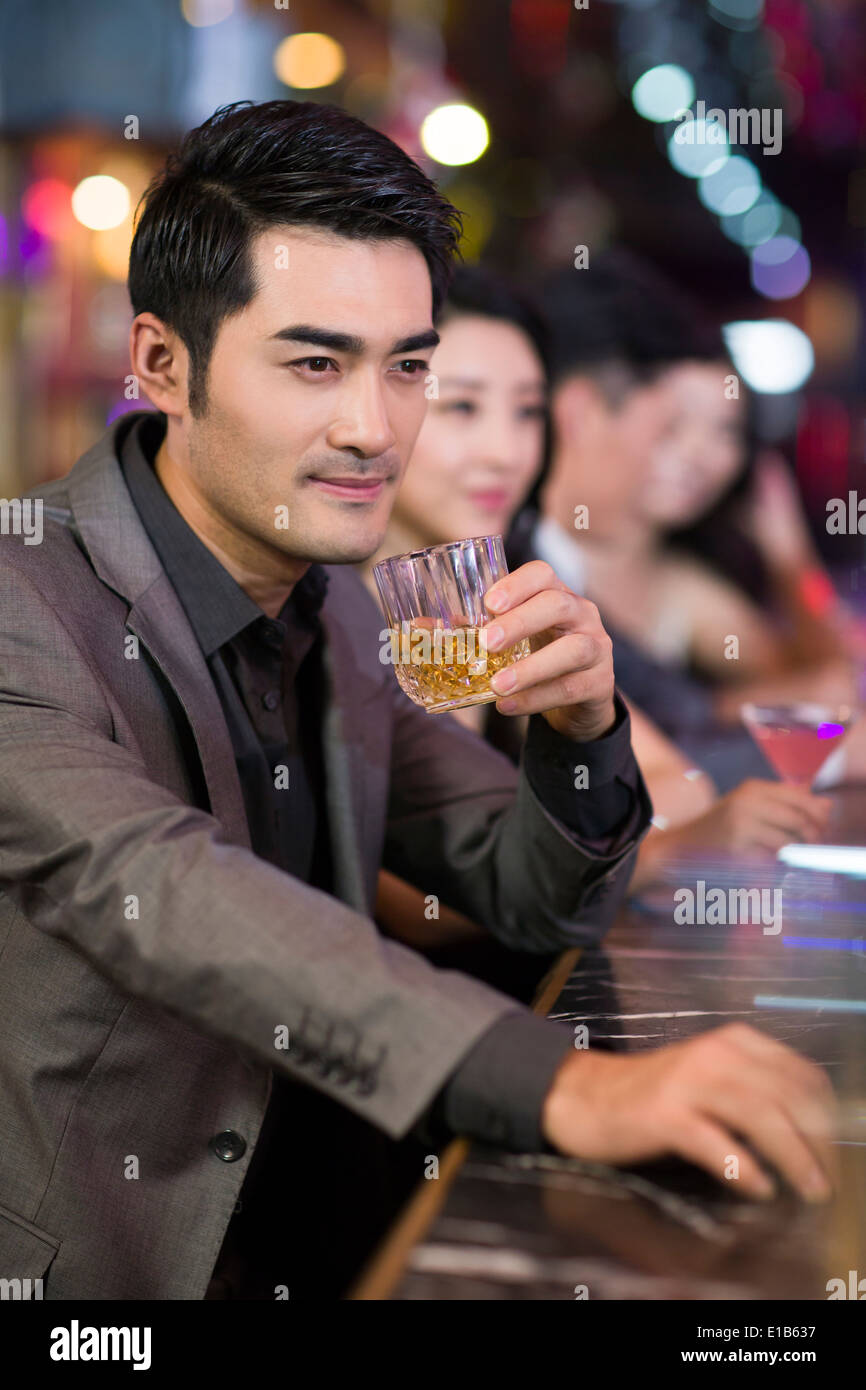 Young man drinking alcohol in bar Stock Photo - Alamy