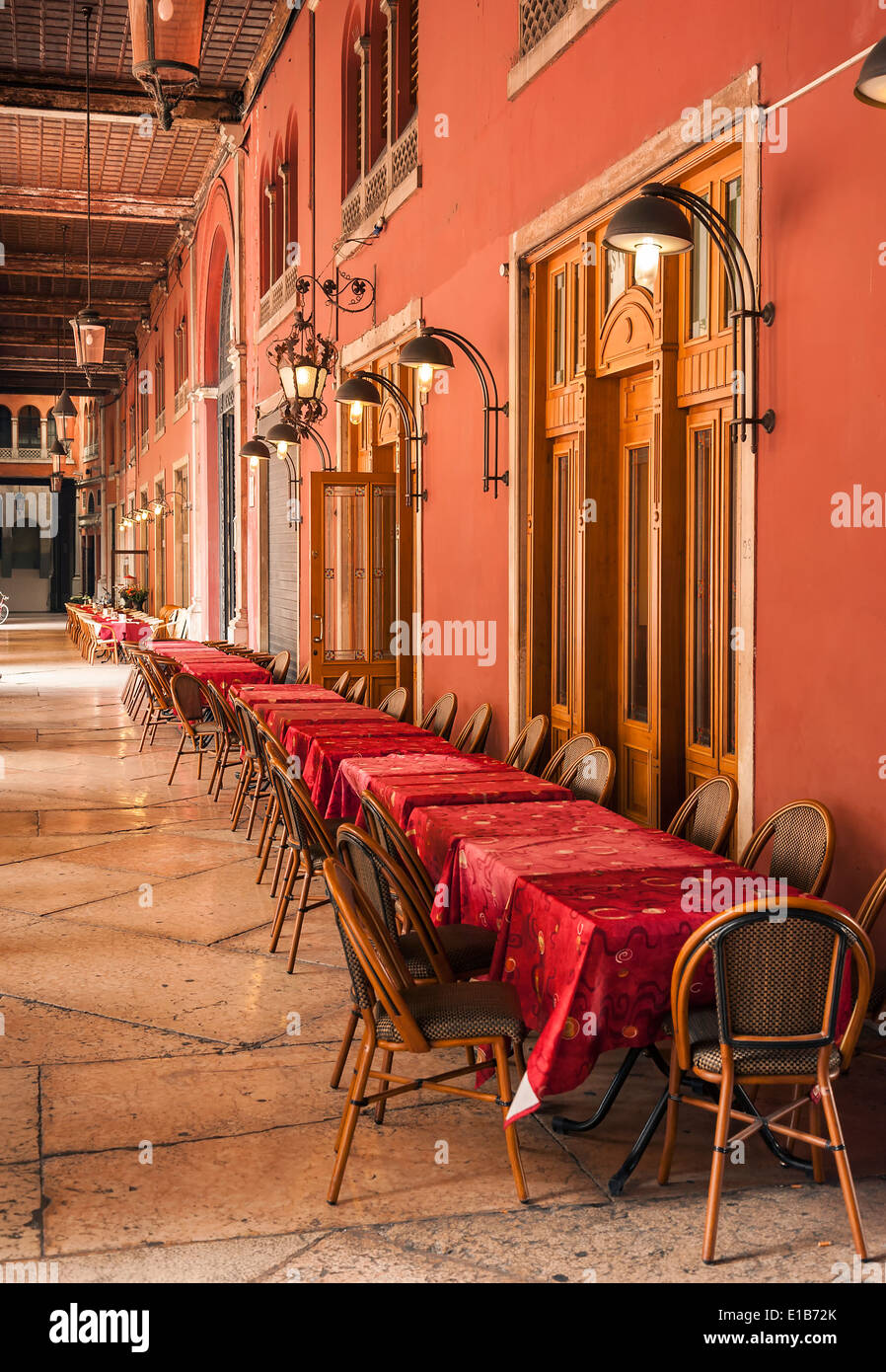 Restaurant tables and chairs along a colourful corridor within the ...