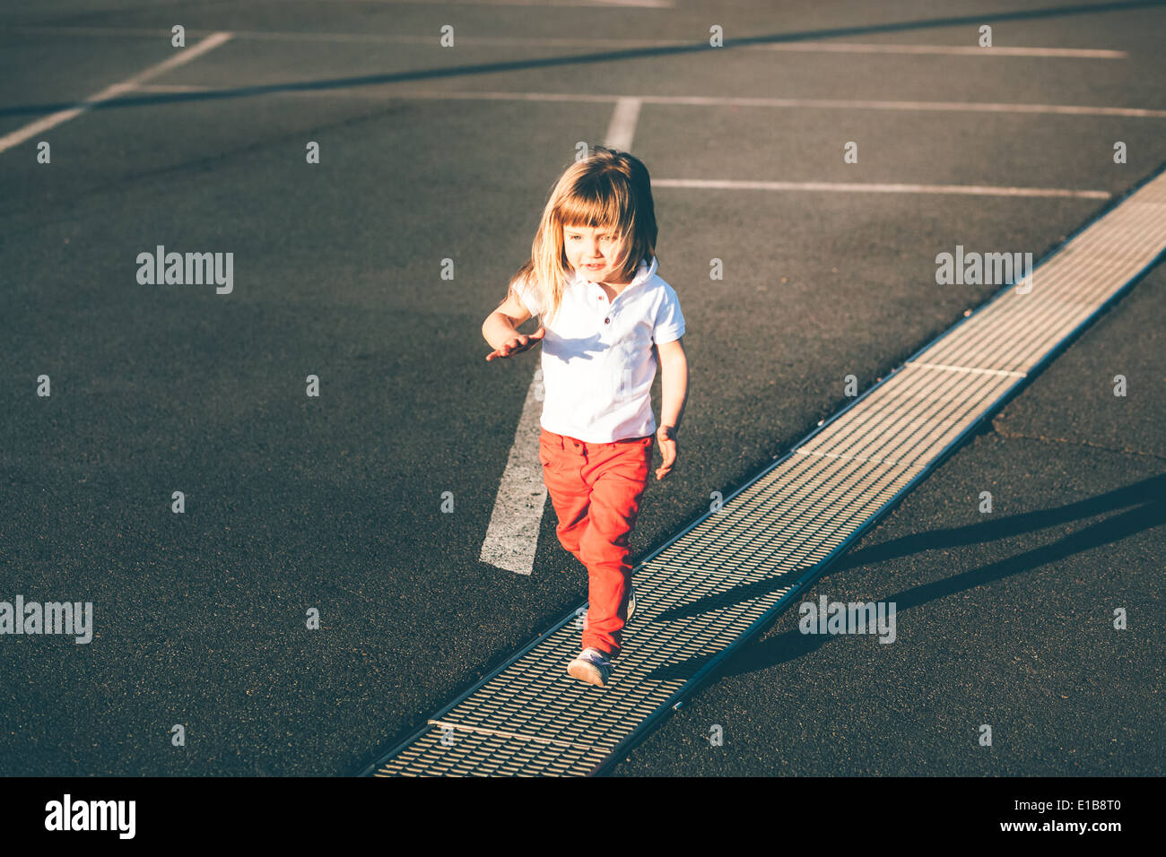 Little girl running away on the road Stock Photo - Alamy
