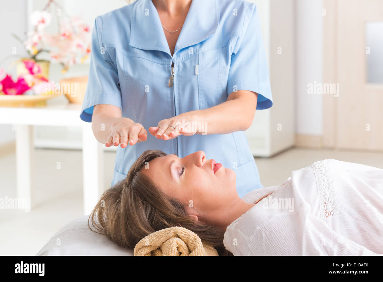 Professional Reiki healer doing reiki treatment to young woman Stock ...