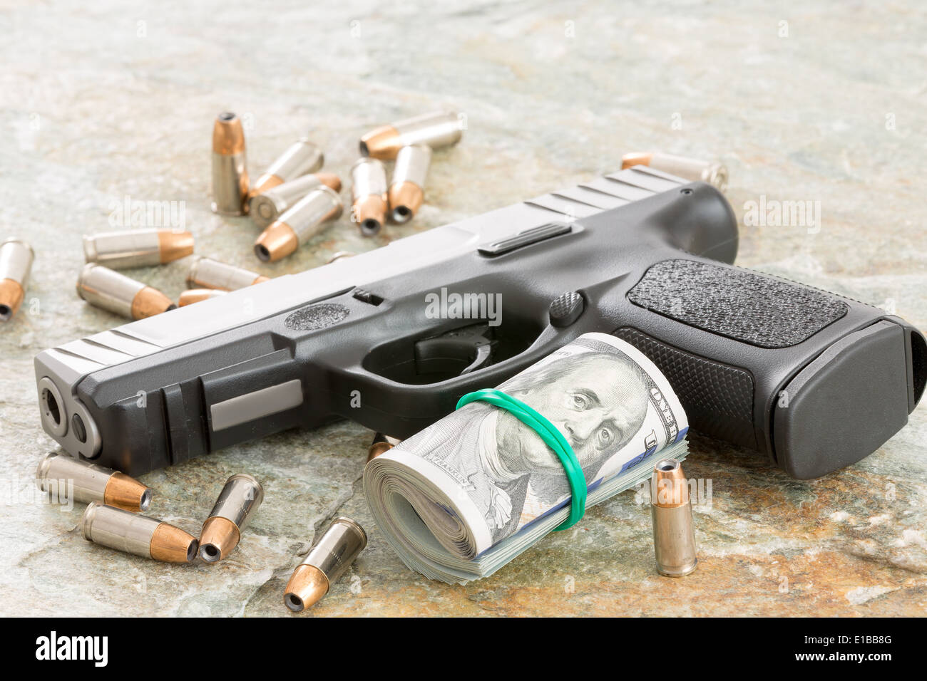 Conceptual image of a handgun with a roll of money surrounded by ...