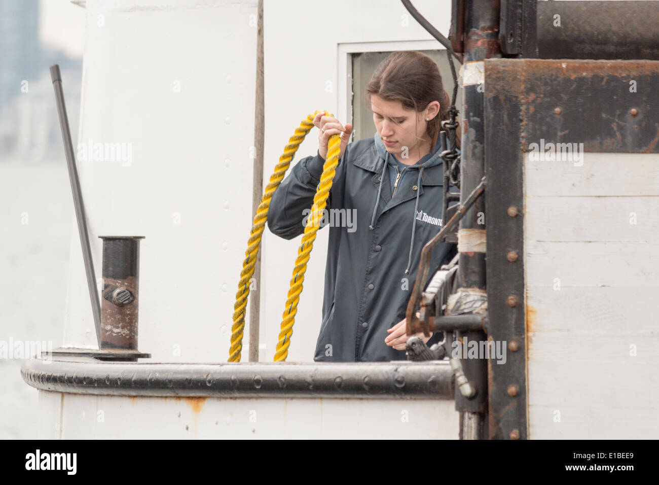 Female dock worker prepares the rope on a ferry for docking Stock Photo ...