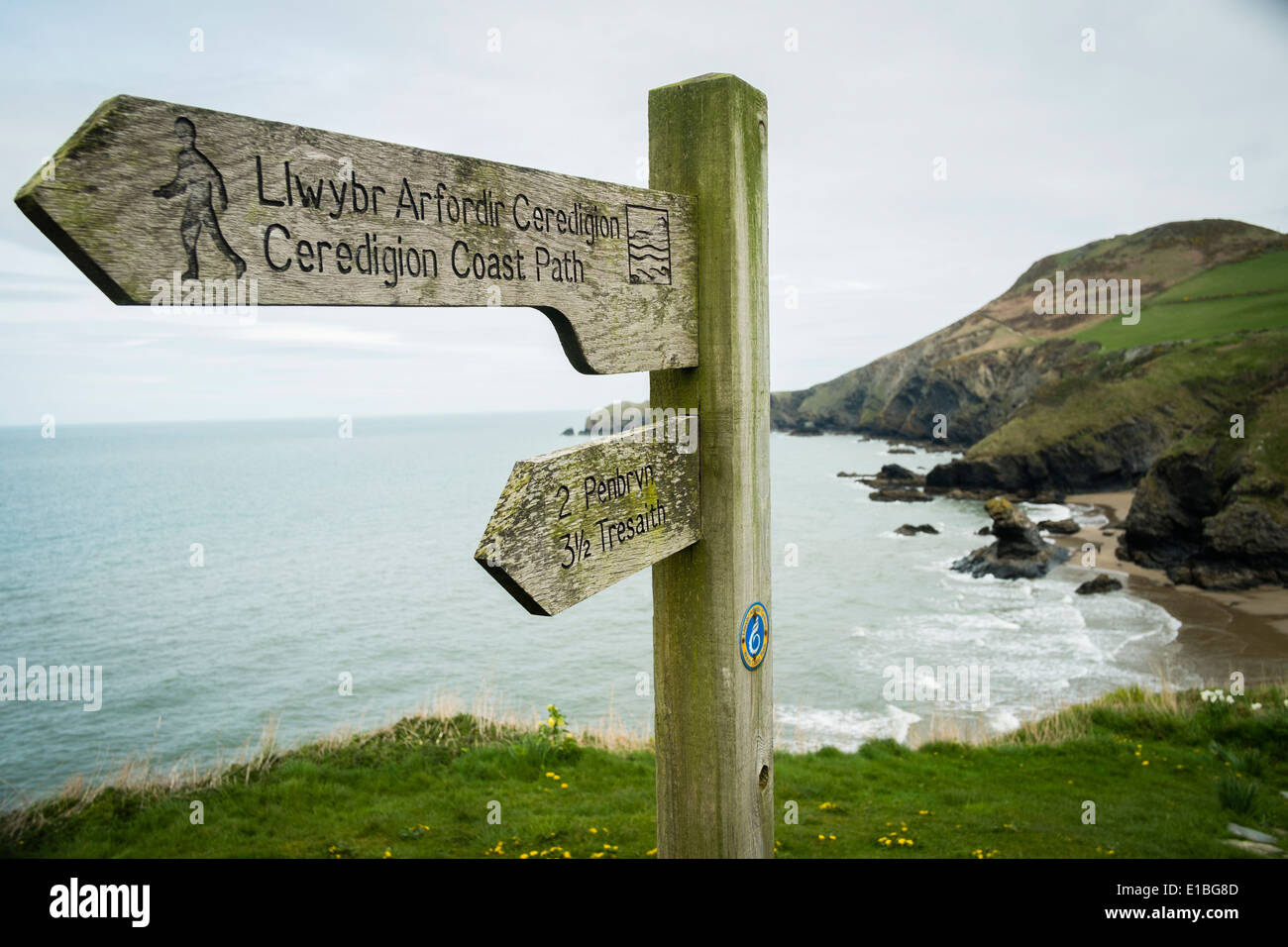 Coastline and wooden fingerpost sign for the ceredigion coast path at ...