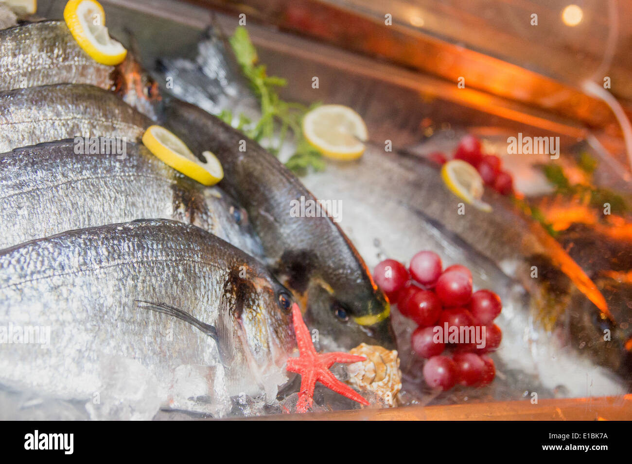 fried fish with lemon and starfish on the plate in the fridge Stock ...