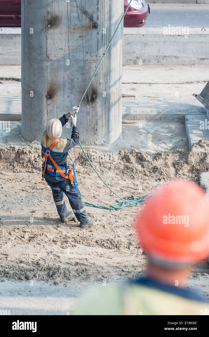 Worker levels provision of plate lifting by crane Stock Photo - Alamy