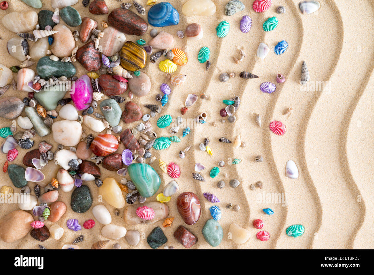 Pebbles, gemstones and shells scattered in a decorative arrangement on ...