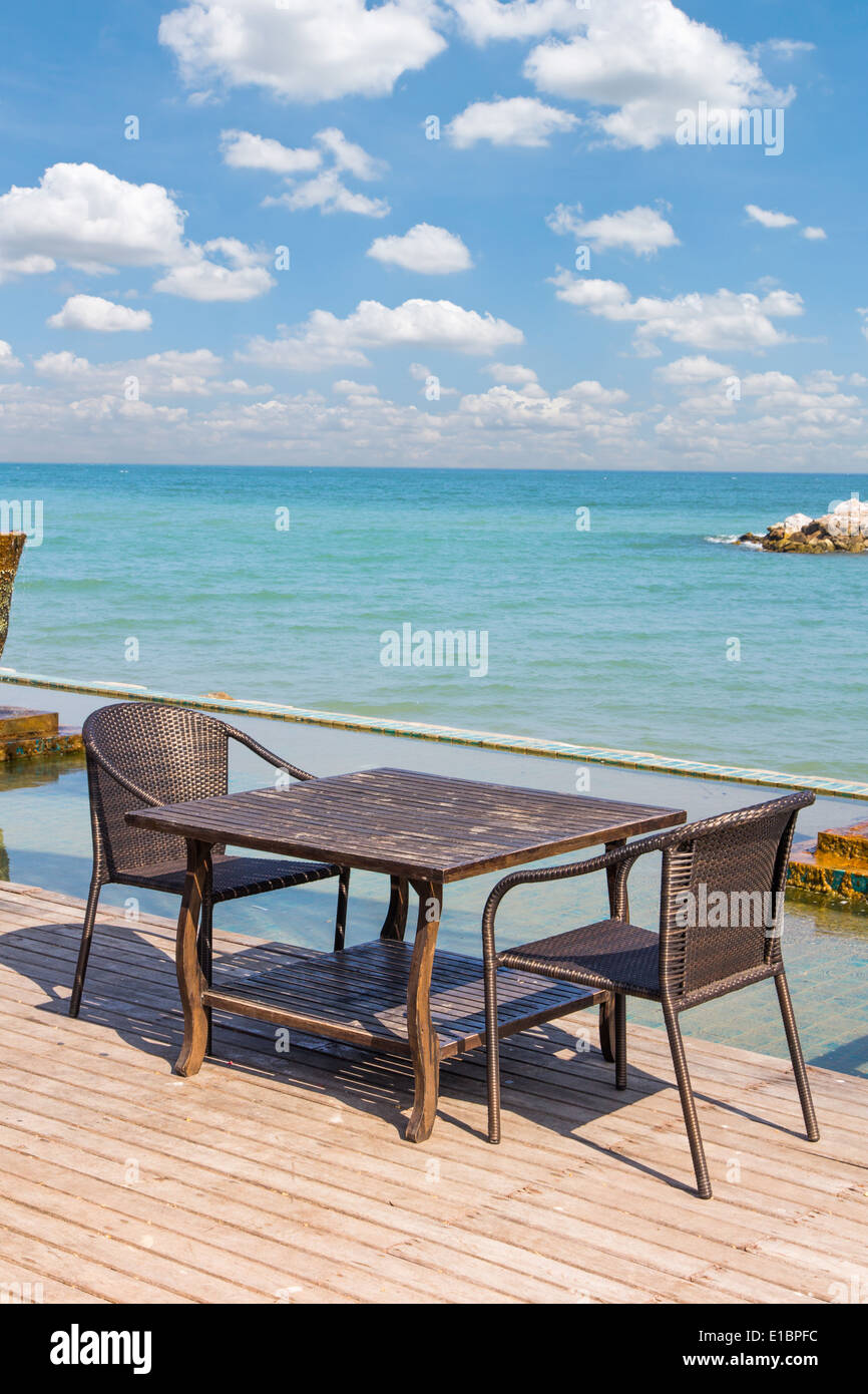 Table chair set beside sea scenic background Stock Photo - Alamy