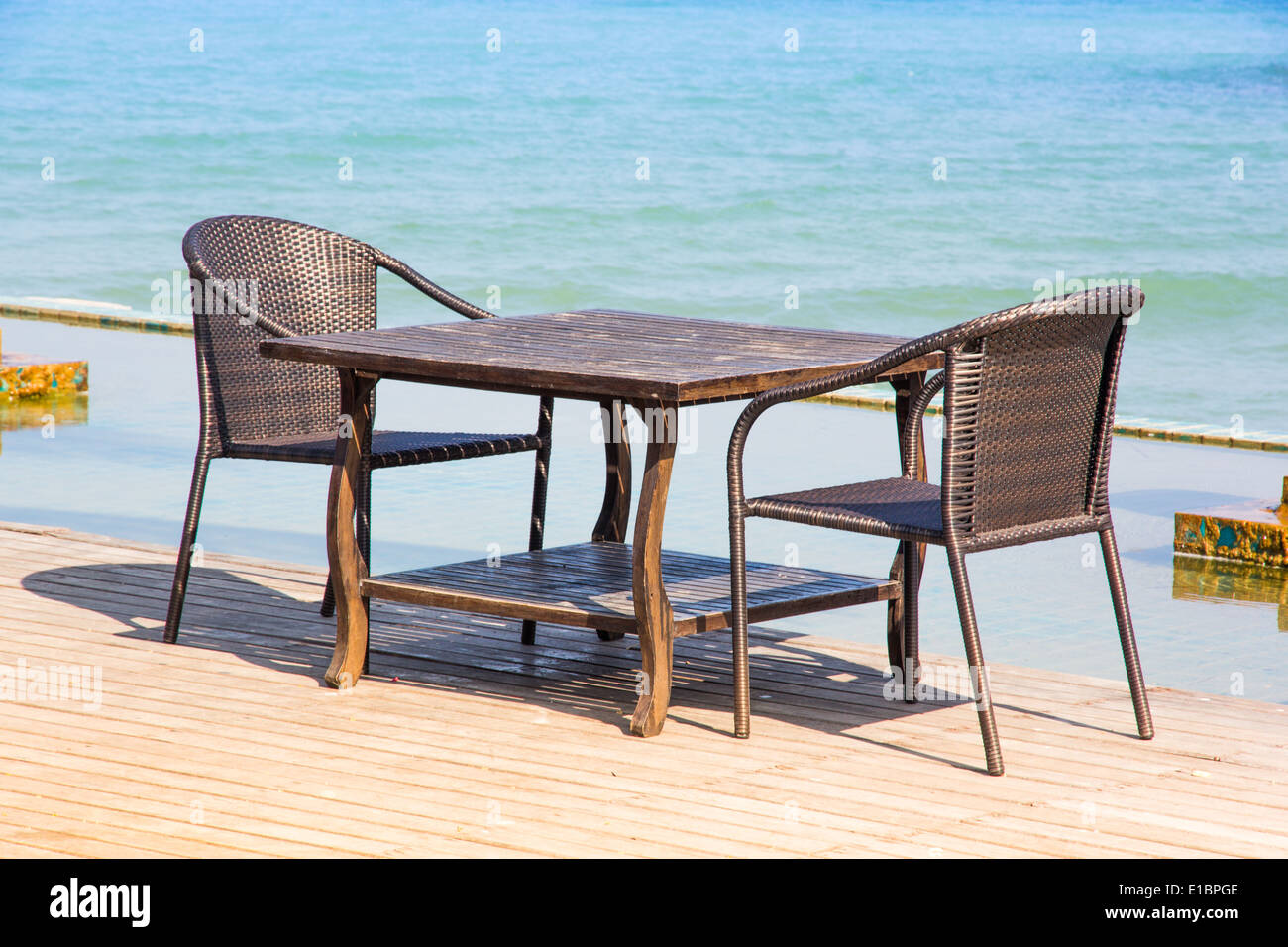 Table chair set beside sea scenic background Stock Photo - Alamy