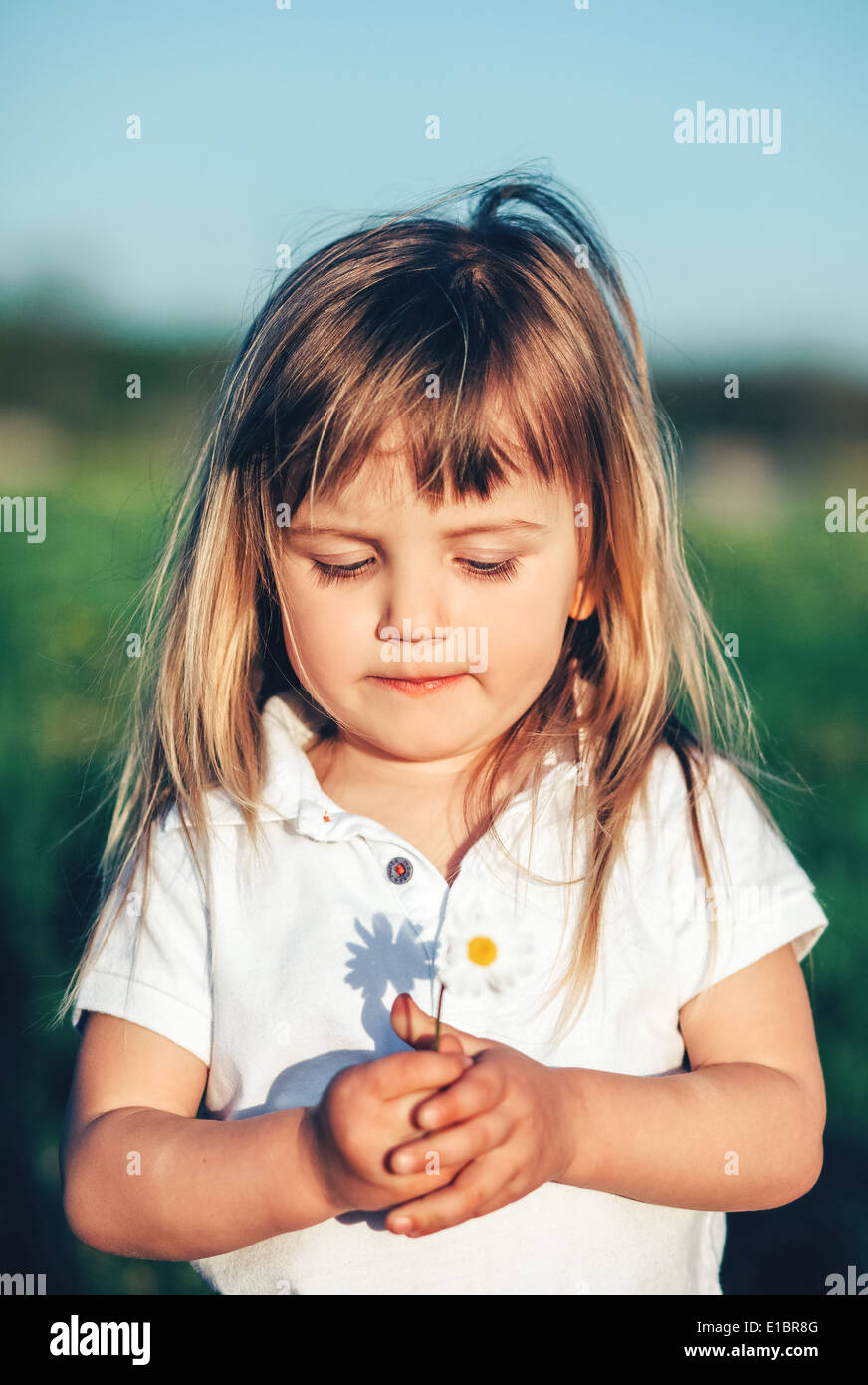 Baby girl holding little flower Stock Photo - Alamy