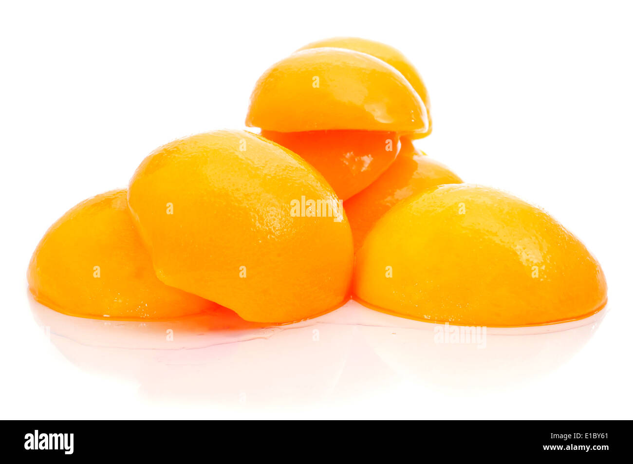 some peeled and halved peaches in syrup on a white background Stock ...