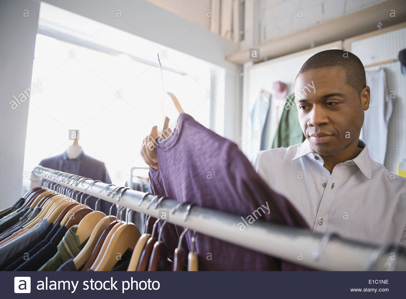 Man browsing clothing on rack hi-res stock photography and images - Alamy