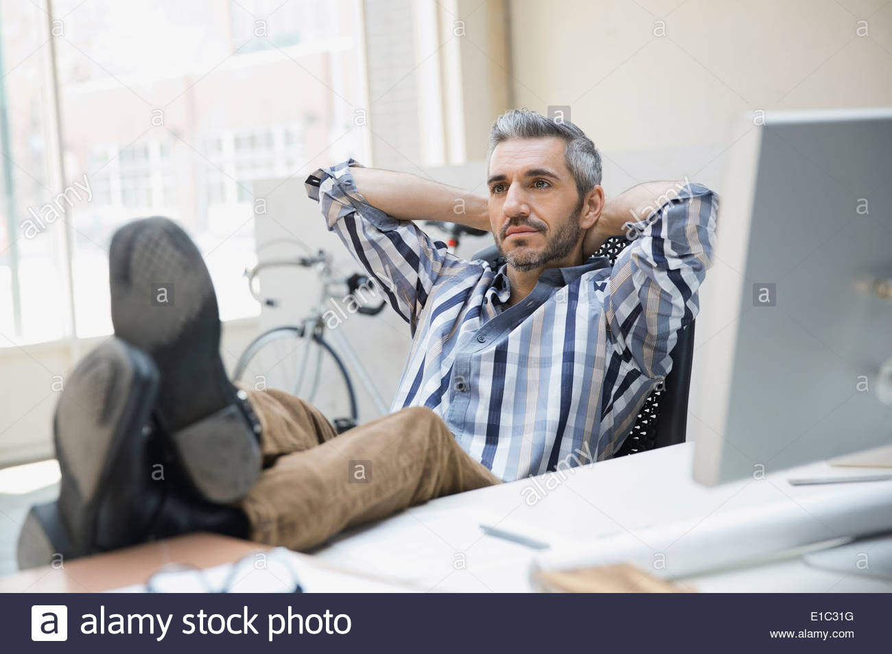 Feet on desk in front of man hi-res stock photography and images - Alamy