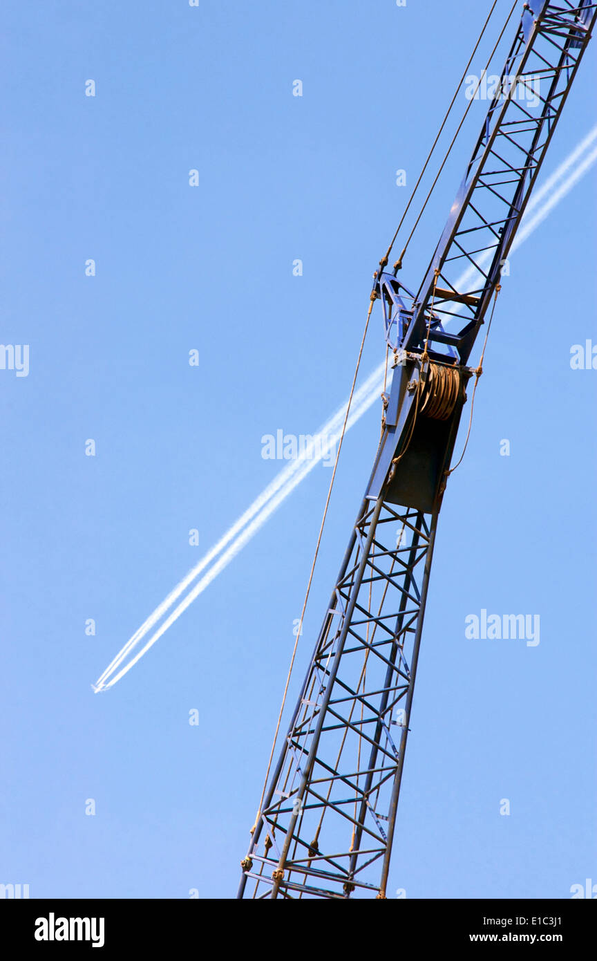 Crane and high flying jet plane in blue sky Stock Photo - Alamy