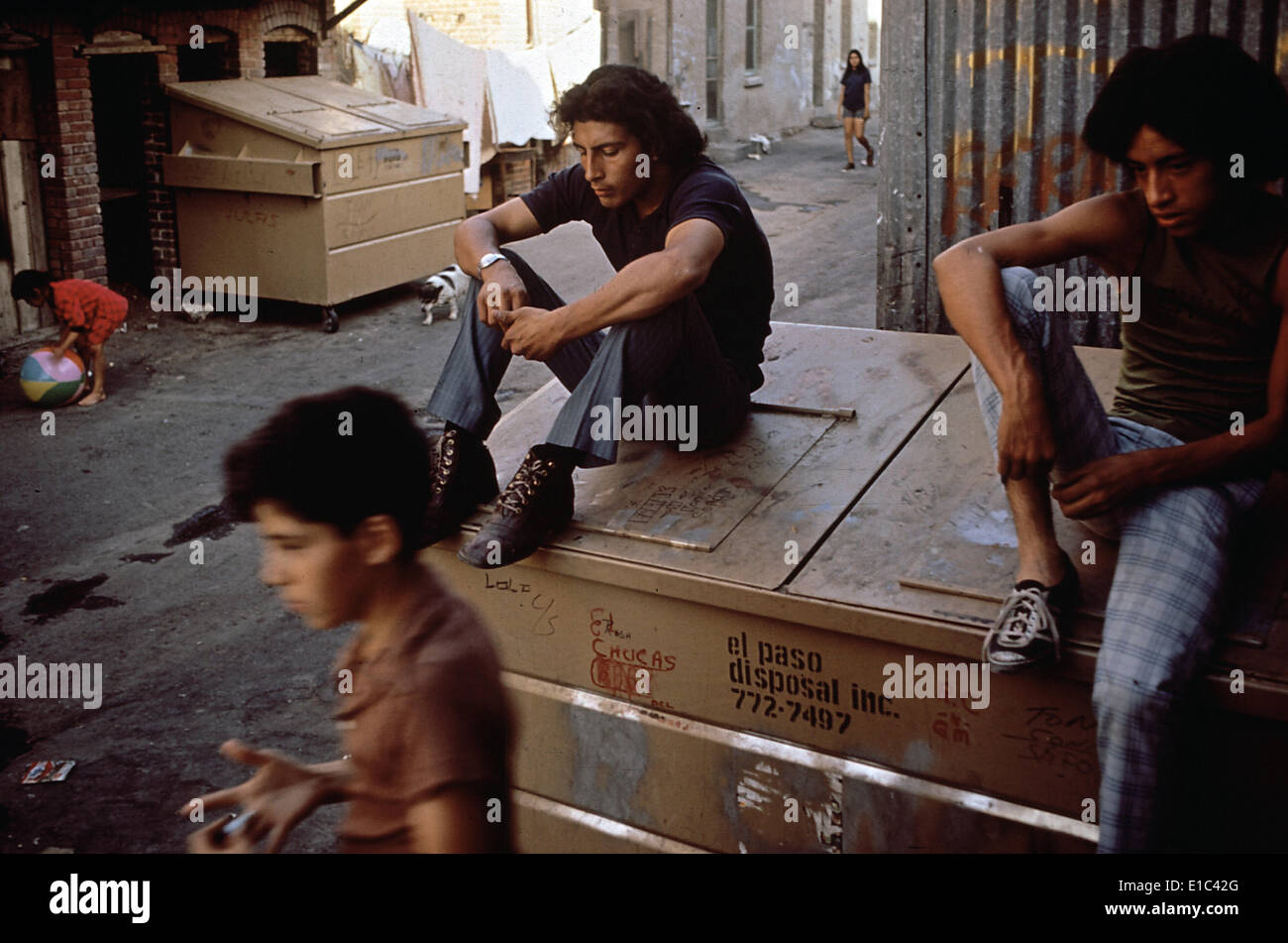 1970s America. Three young chicano men in the barrio area of El Paso ...