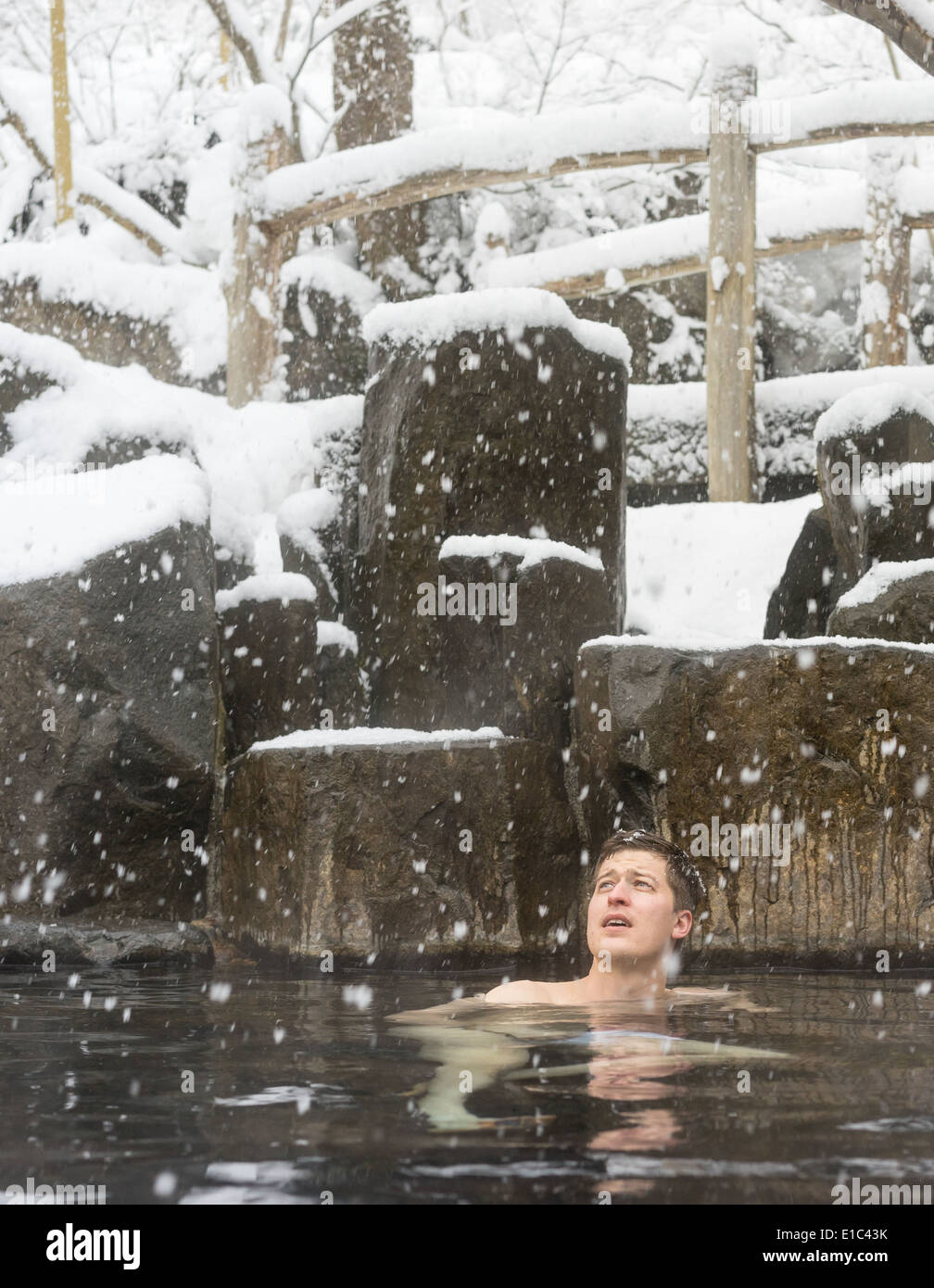 Man soaking in purifying hot spring water in the mountains of Japan ...