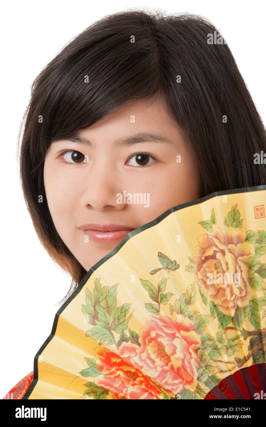 Beautiful Chinese woman wearing a cheongsam and posing with a fan on a ...