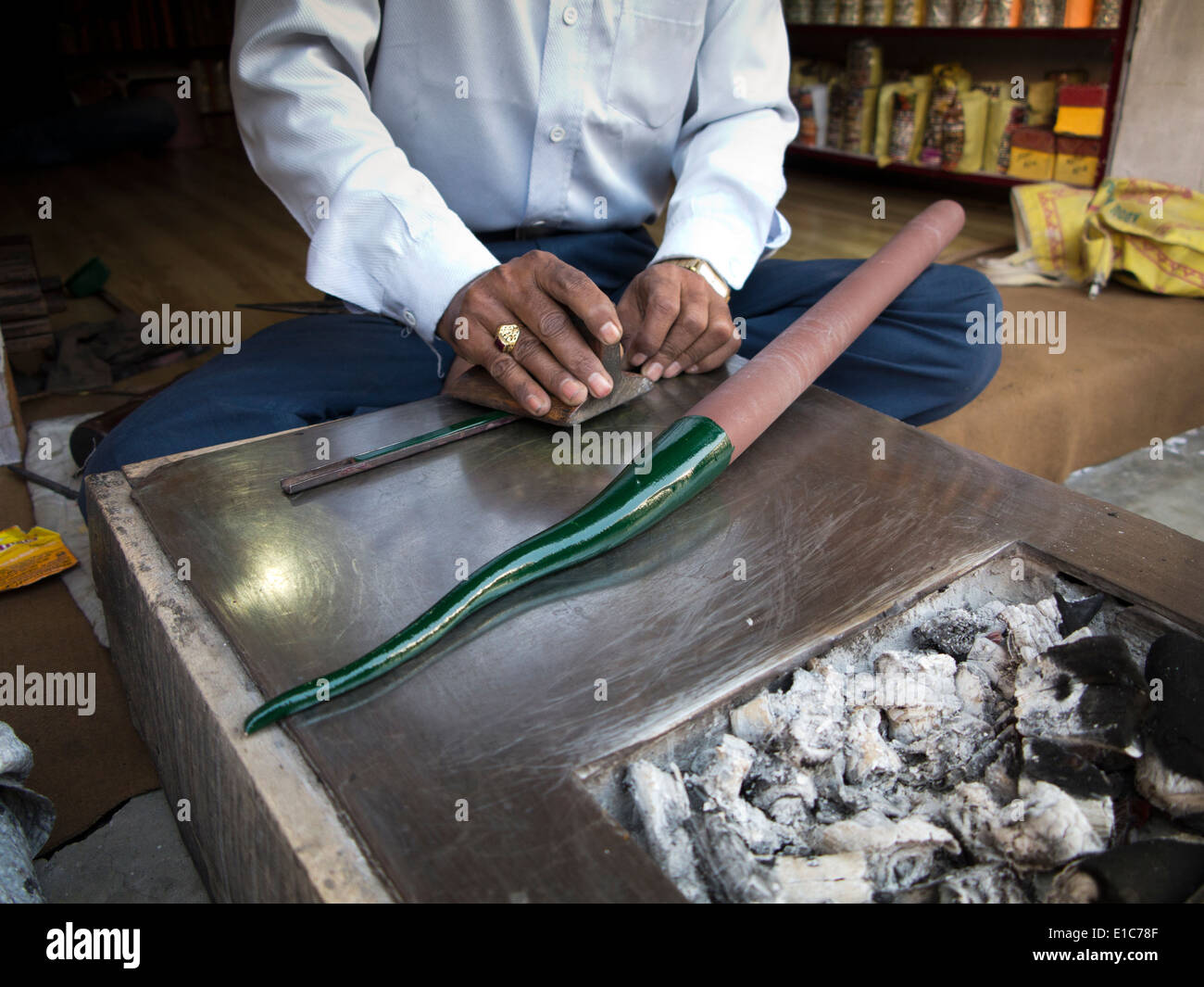 India, Rajasthan, Jodhpur, craftsman making green lac bangle, rolling ...