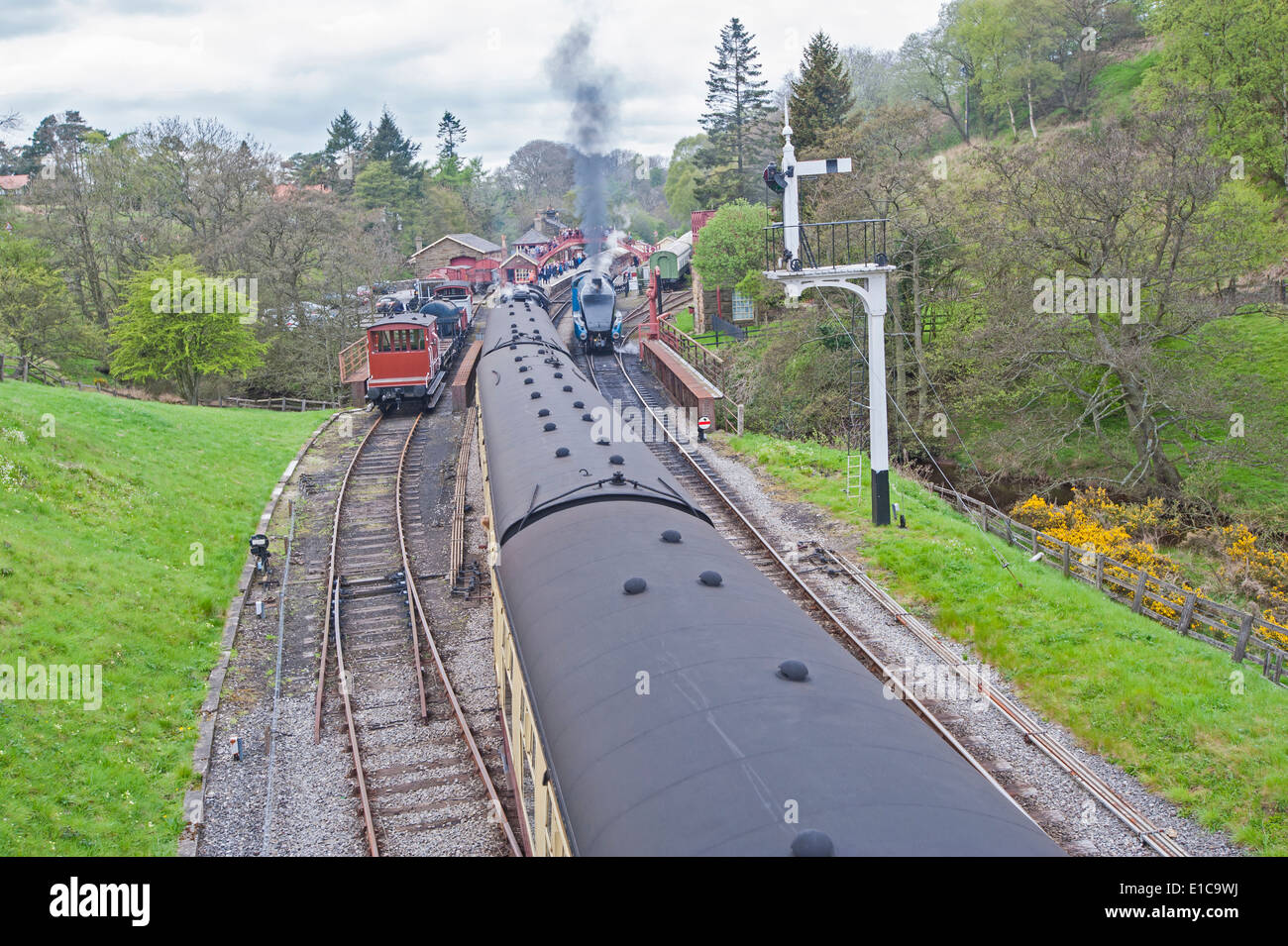 Old english traditional railway station with train on tracks through ...