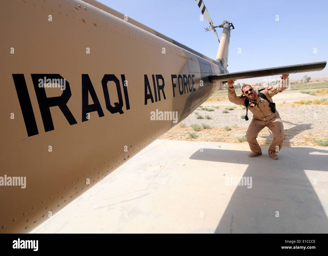 An Iraqi air force pilot performs a preflight check on a UH-1H Huey ...