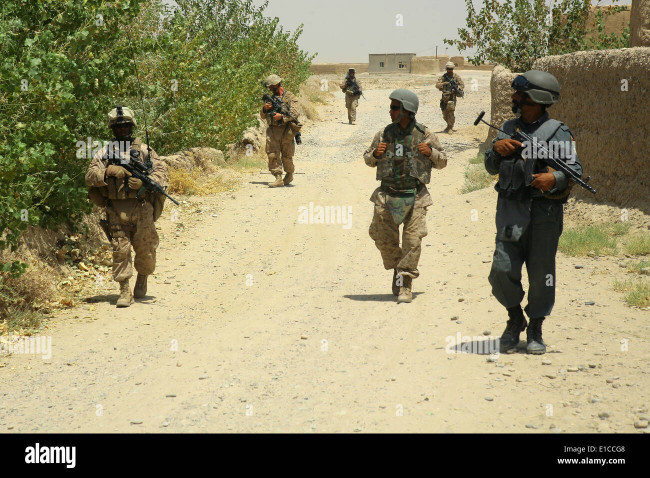 Afghan National Police officers conduct a patrol with U.S. Marines in ...