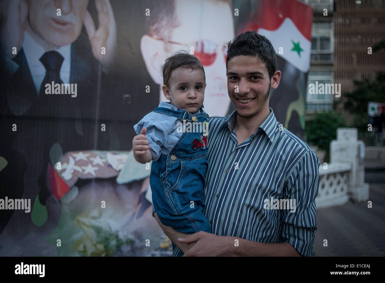 Damascus, Syria. 30th May, 2014. A Syrian with a kid in his arm poses ...