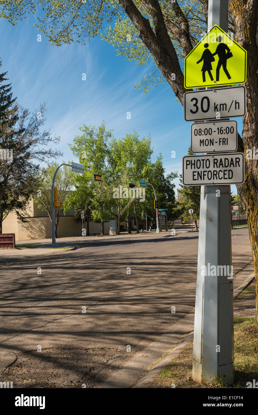 Signs indicating school zone speed limit with school in background, St ...