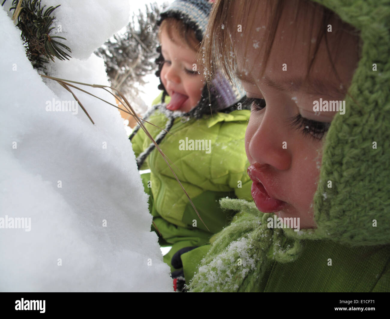 Twins taste snow Stock Photo - Alamy
