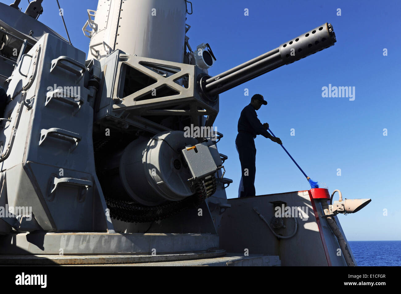 U.S. Navy Fire Controlman 2nd Class Christopher Green cleans a close-in ...