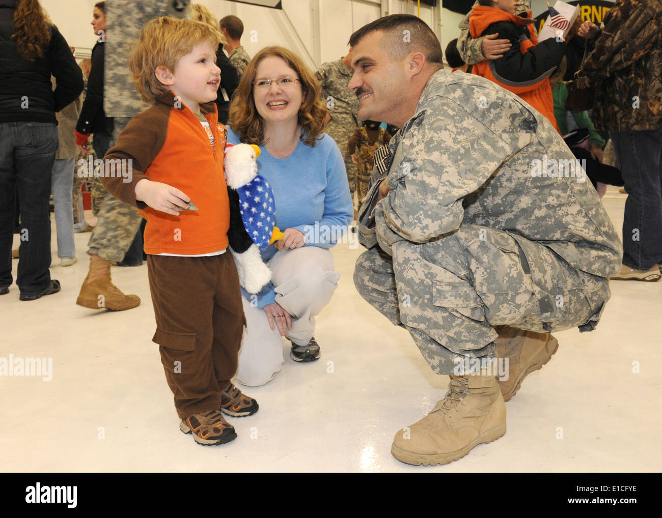 U.S. Army Staff Sgt. Raymond Burge shares a laugh with his wife and son ...