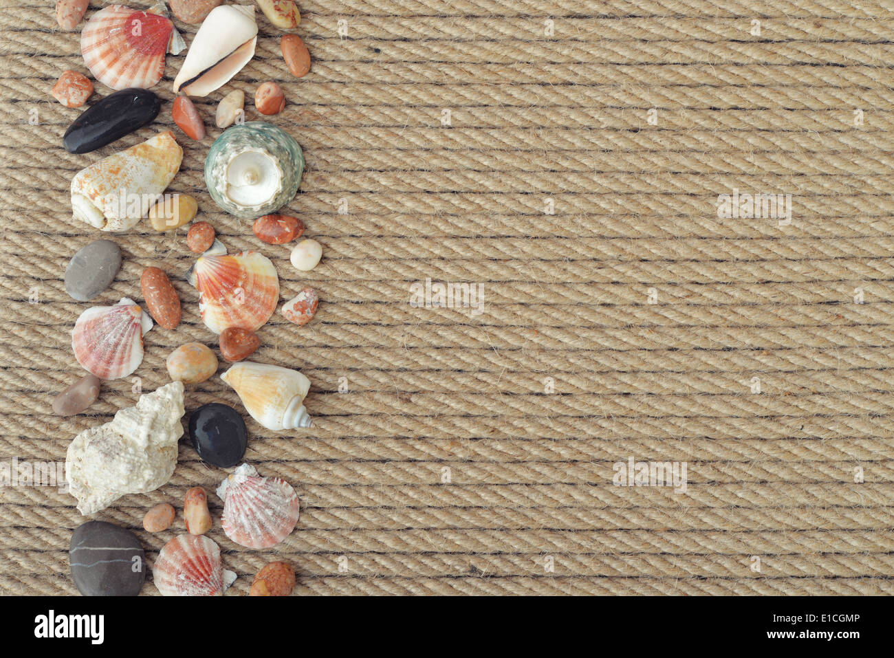 Sea shells and stones on background of rope closeup Stock Photo - Alamy