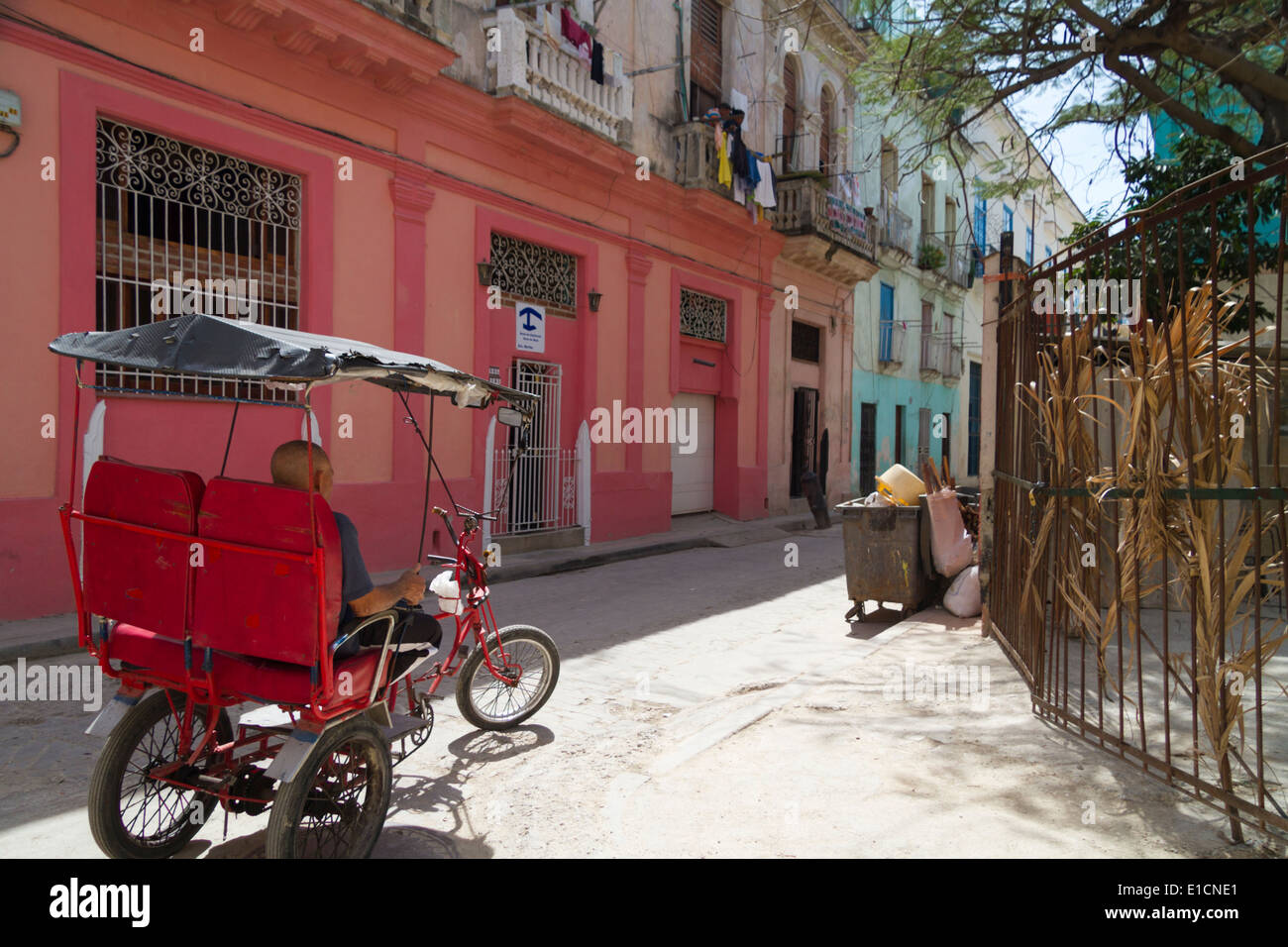 Cuban bicycle taxi driver taking a break in a quiet street in Old Town ...